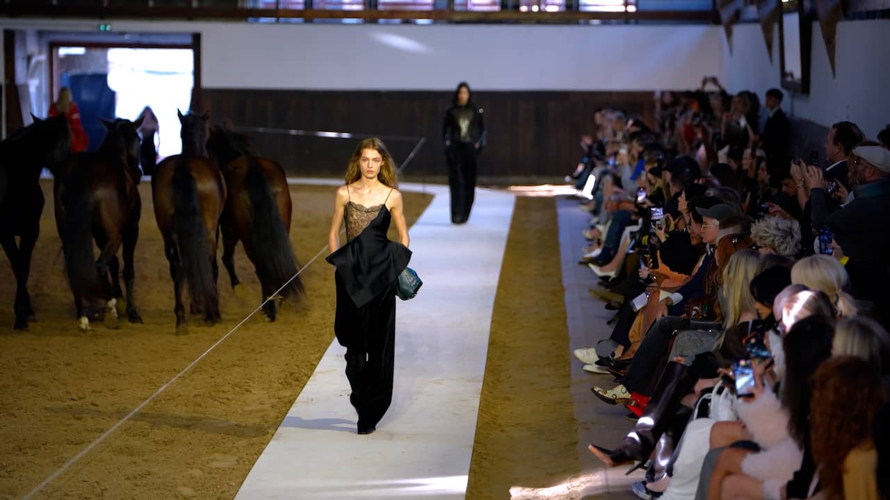 Modellen paraderen tussen de paarden tijdens Paris Fashion Week | NU.nl